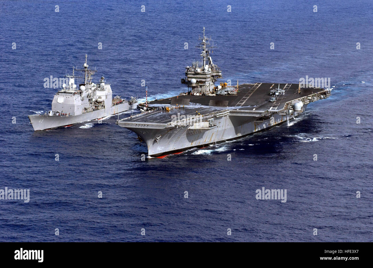 USS Vincennes (CG 49) and USS Kitty Hawk (CV 63) steam side-by-side ...