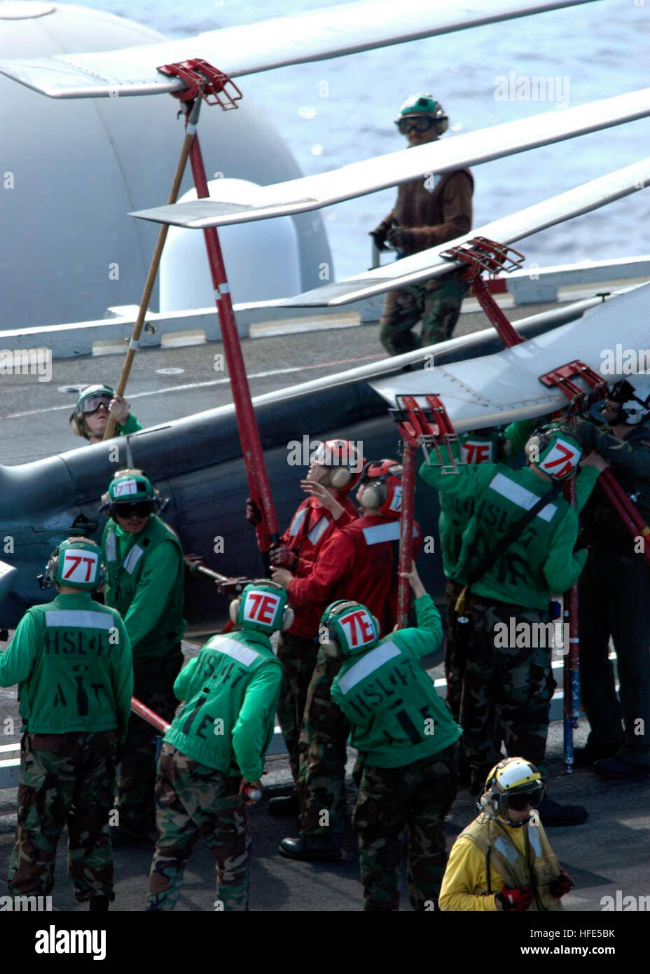 Sailors of HSL-47 fold and stow the rotor blades of an SH-60B Seahawk ...