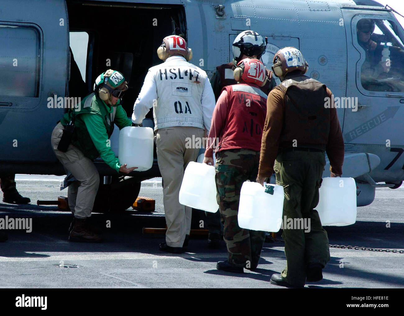 Flight deck personnel load purified drinking water onto SH-60B Seahawk ...