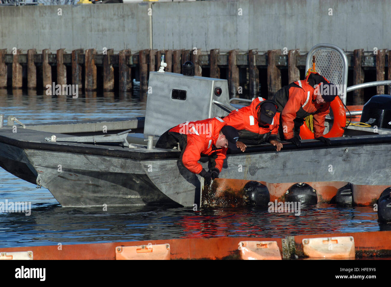 Naval Station Everett Port Operations personnel deploy an oil ...