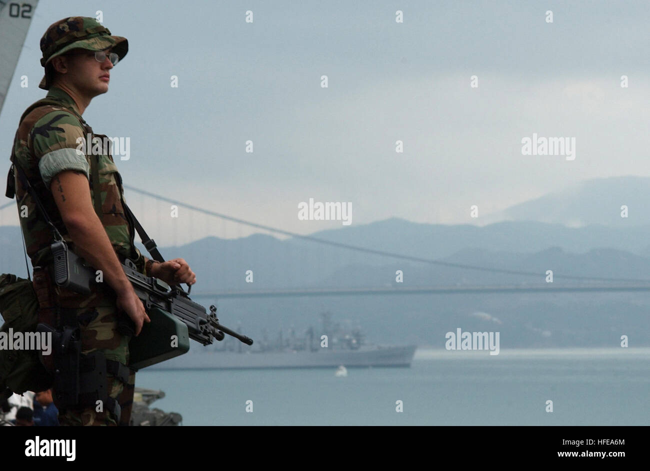 Sailor stands watch with M-4 rifle aboard USS Kitty Hawk (CV 63) in ...