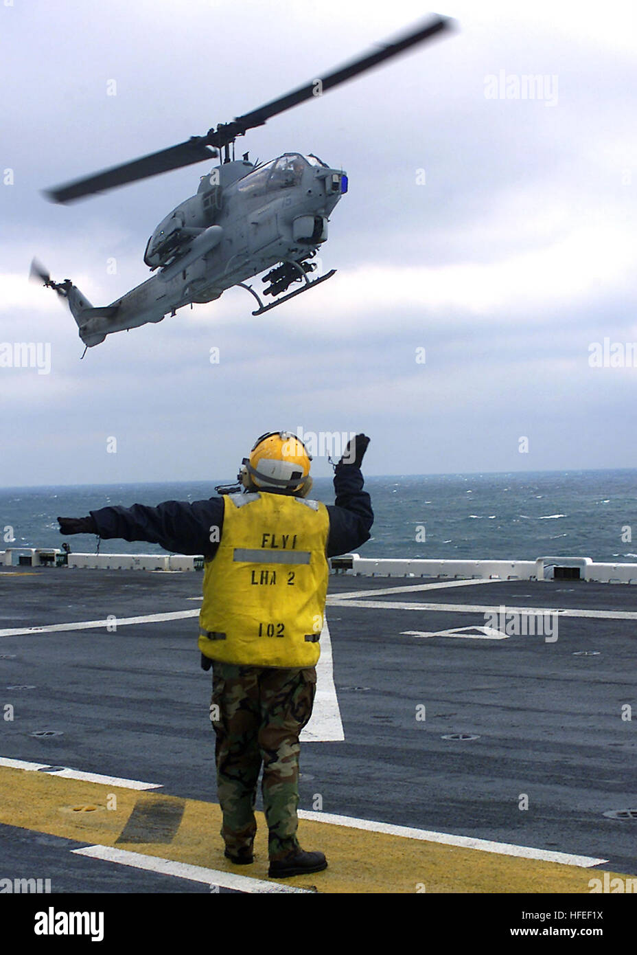 Aviation Boatswain's Mate aboard USS Saipan (LHA-2) signals an AH-1W ...