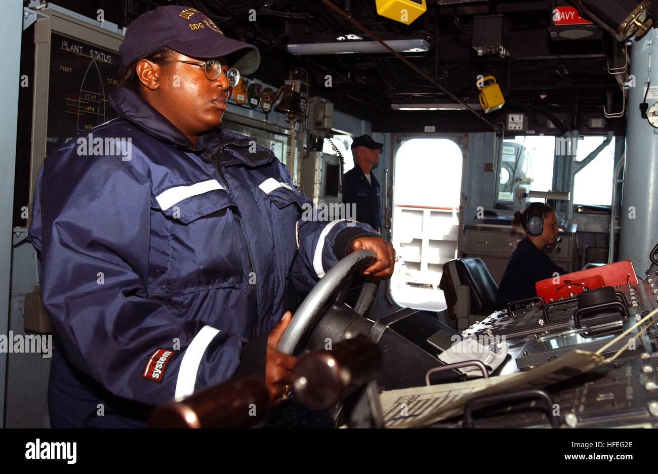 A helmsman operates the ship’s control console on the bridge of USS ...