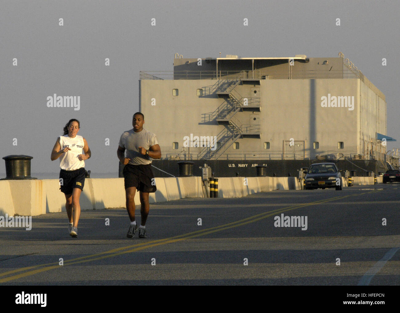 Midshipmen and exchange students jog past the APL-61 barracks craft ...