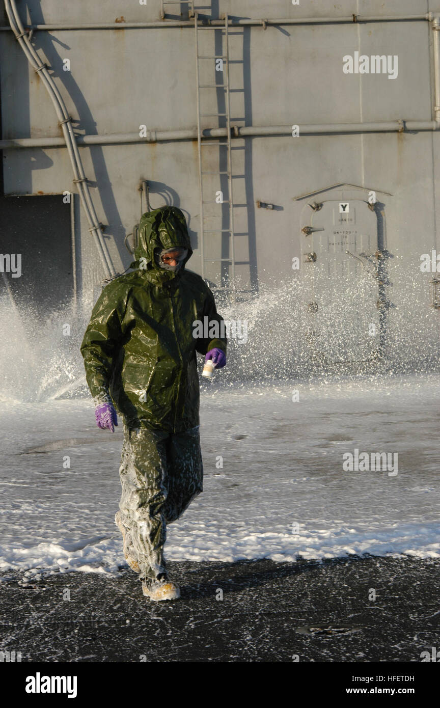 A sailor aboard USS Kitty Hawk brings a water and Aqueous Film Forming ...