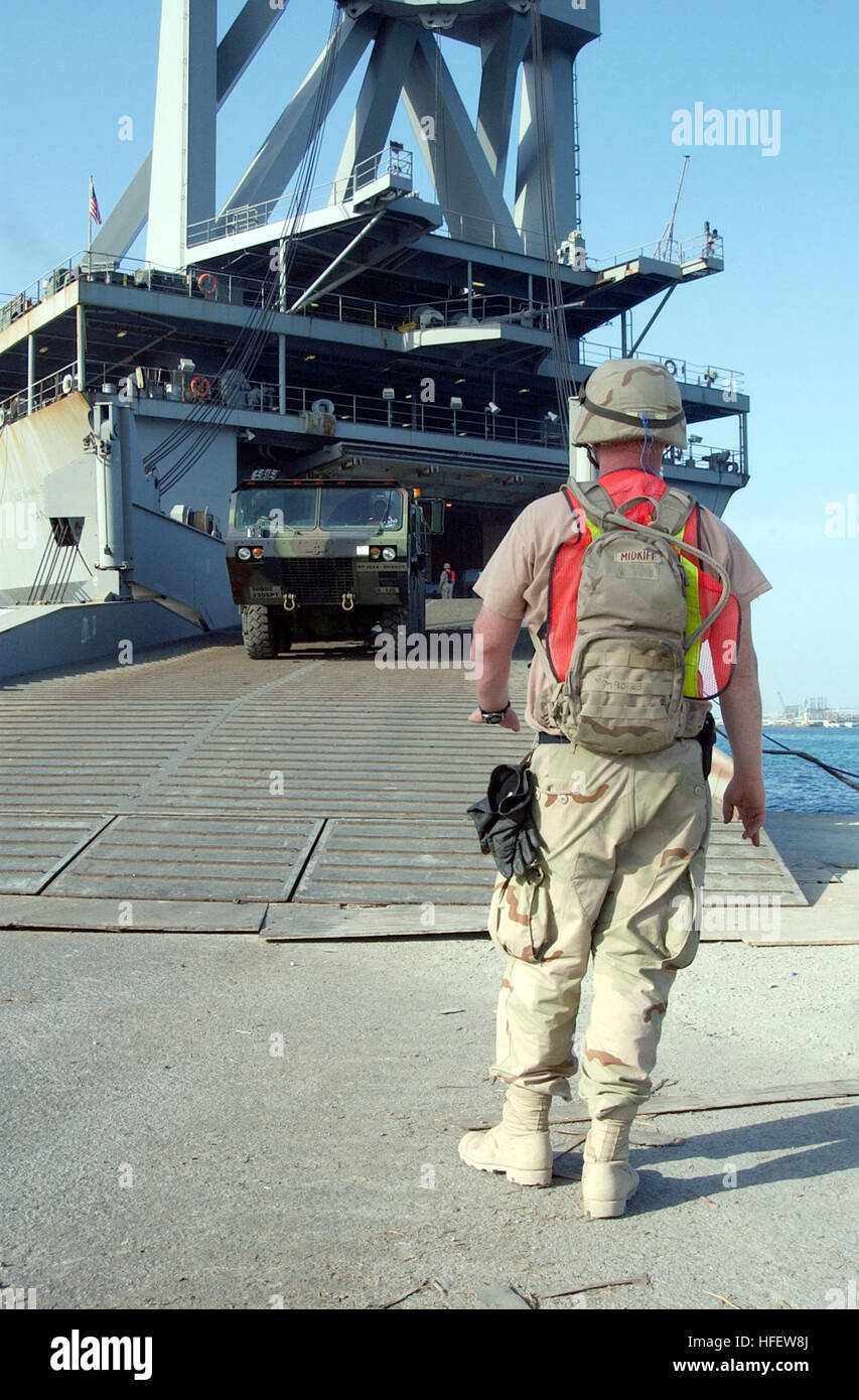 A U.S. Marine monitors a M-977 HEMTT unloading from USNS Bellatrix (T ...