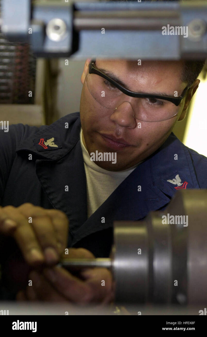 A Machinery Repairman 2nd Class completes threading on a lathe in the ...