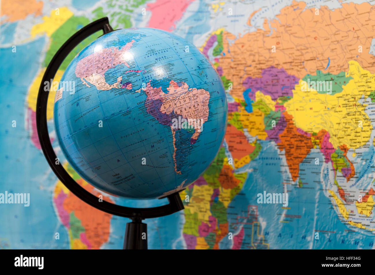 Closeup of a globe with asia and africa and a world map with north and ...