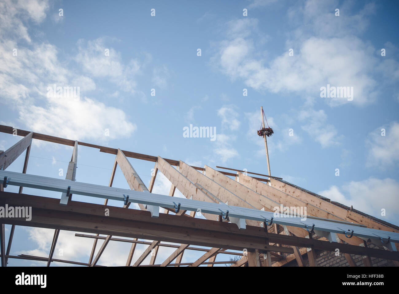 Topping-out ceremony with a wreath on the top of the roof construction ...