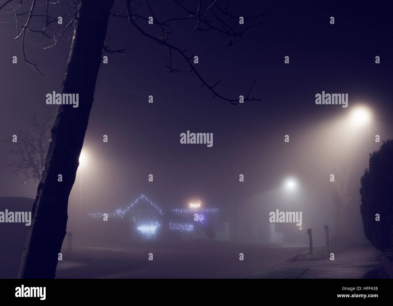 Foggy Street with House and Christmas Lights Stock Photo - Alamy