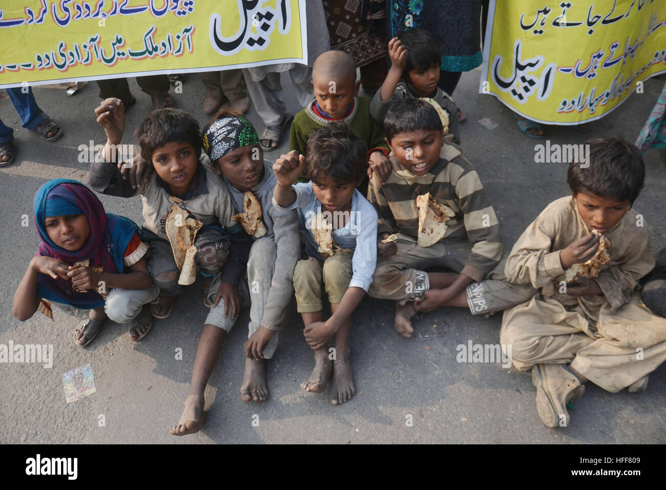 Pakistani poor people hold dry bread as they are protesting against a ...