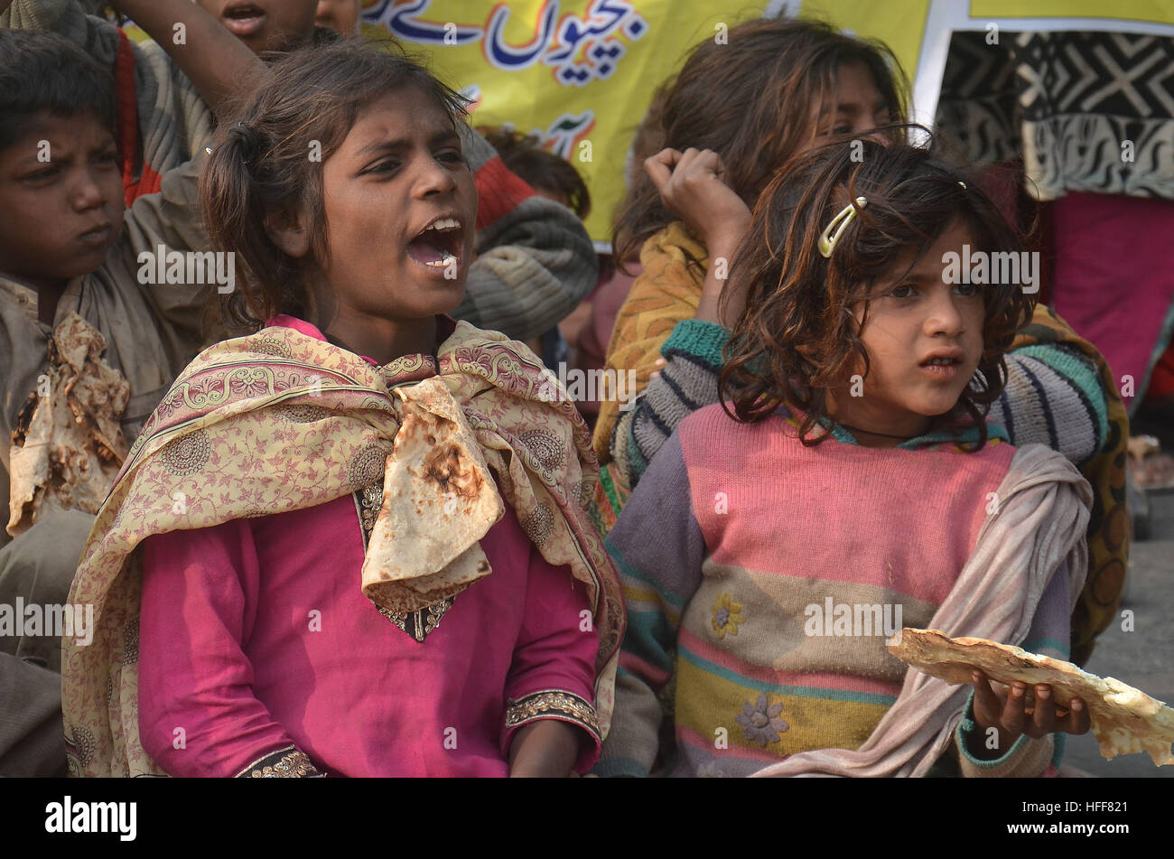 Pakistani poor people hold dry bread as they are protesting against a ...