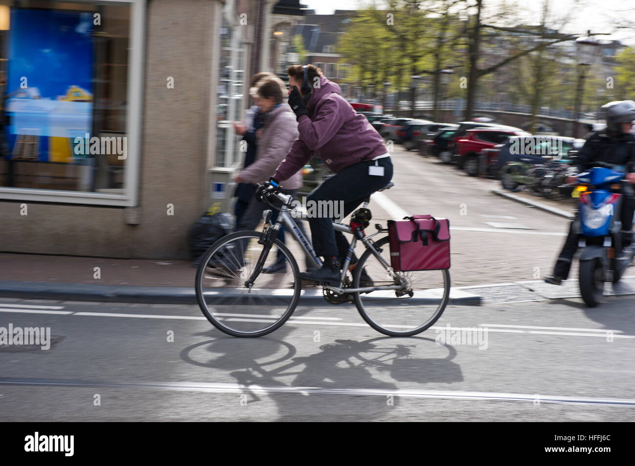 A male cyclist using his phone on the street on Amsterdam, Holland ...