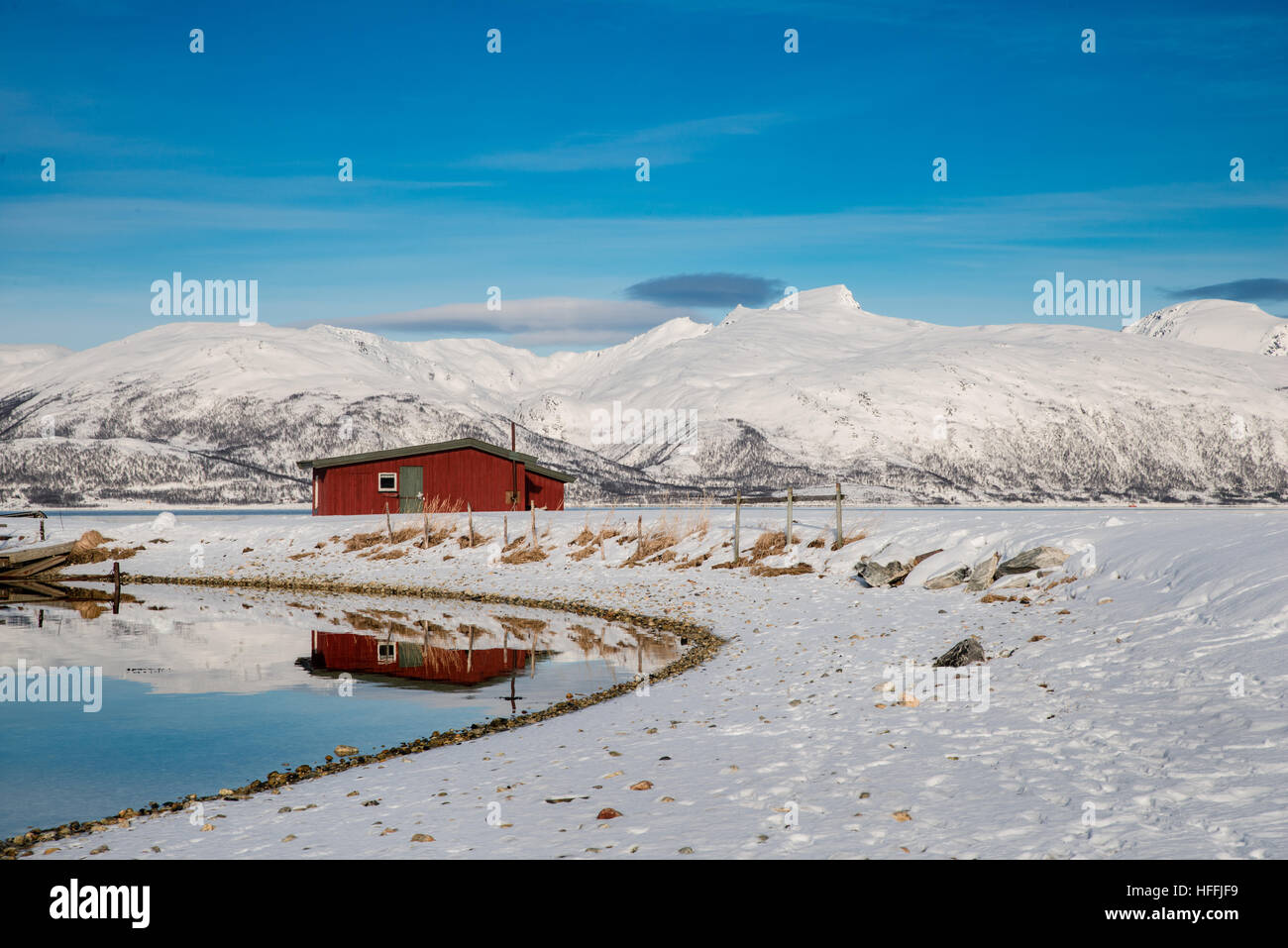 Snowy beach by the cold sea with peaks in the background Tromso, Norway ...