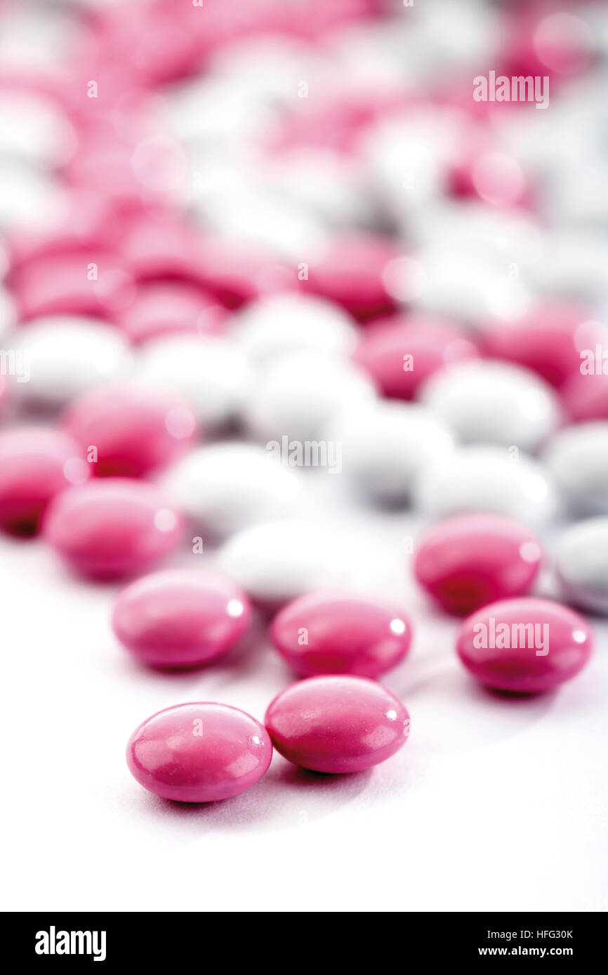 Pink and white candy-coated chocolates Stock Photo - Alamy