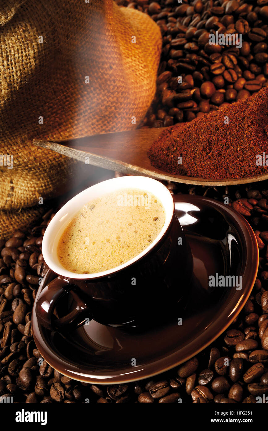 Cup of coffee atop a bed of coffee beans Stock Photo - Alamy