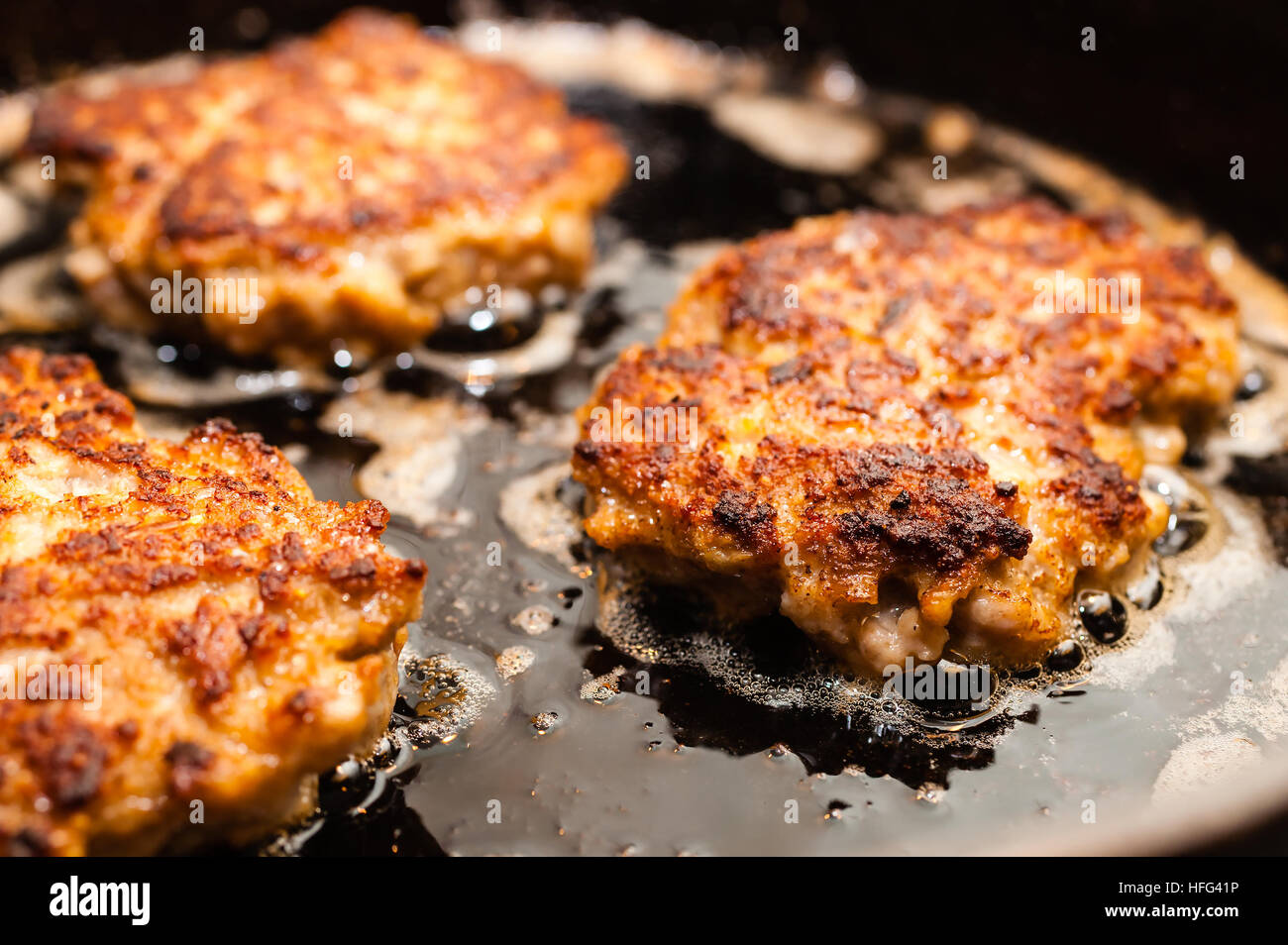 Golden brown meat patties on hot cast iron skillet. Hot butter form ...