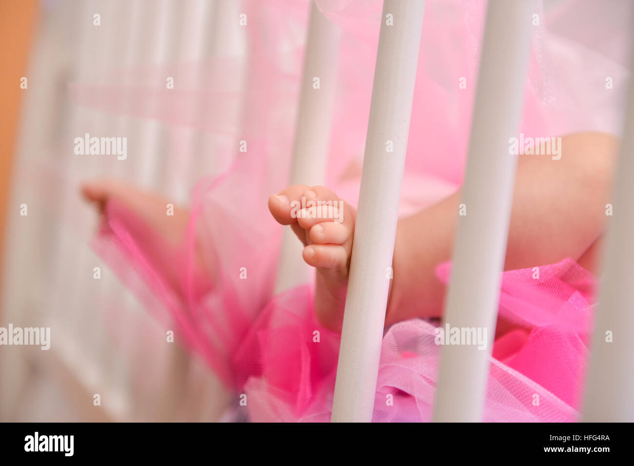 Foot baby in the crib in natural light Stock Photo - Alamy
