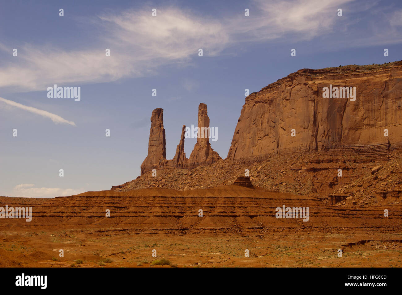 Rock formation called the three sisters, with jet stream clouds and red ...