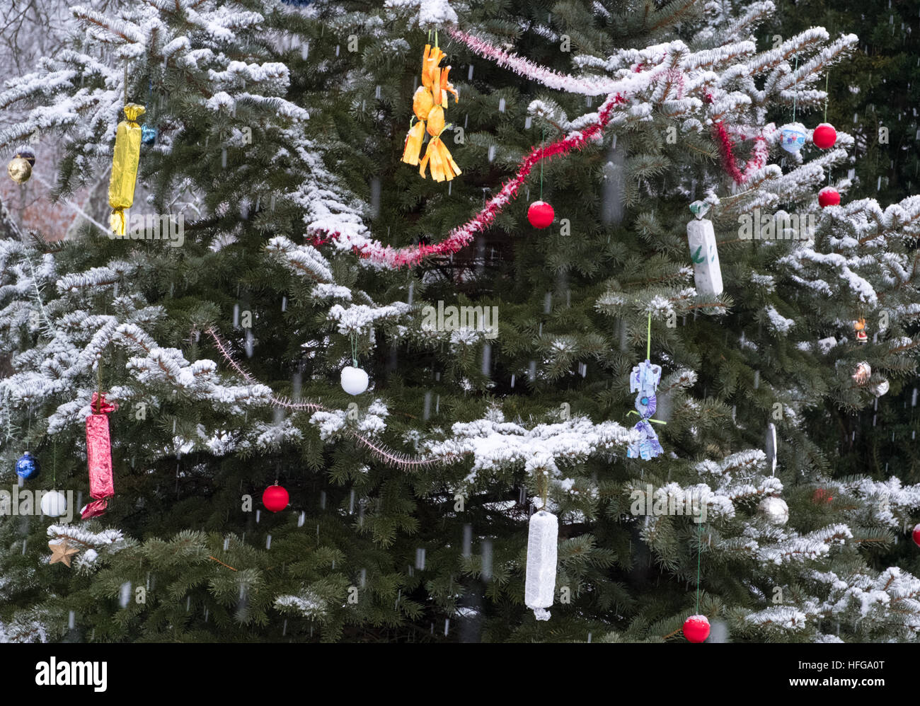 Snow falling on a Christmas tree decorated with sweets Stock Photo - Alamy