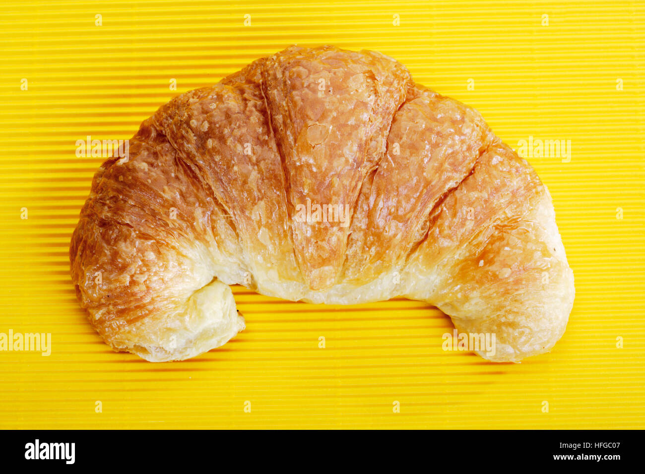 Croissant on a yellow surface Stock Photo - Alamy