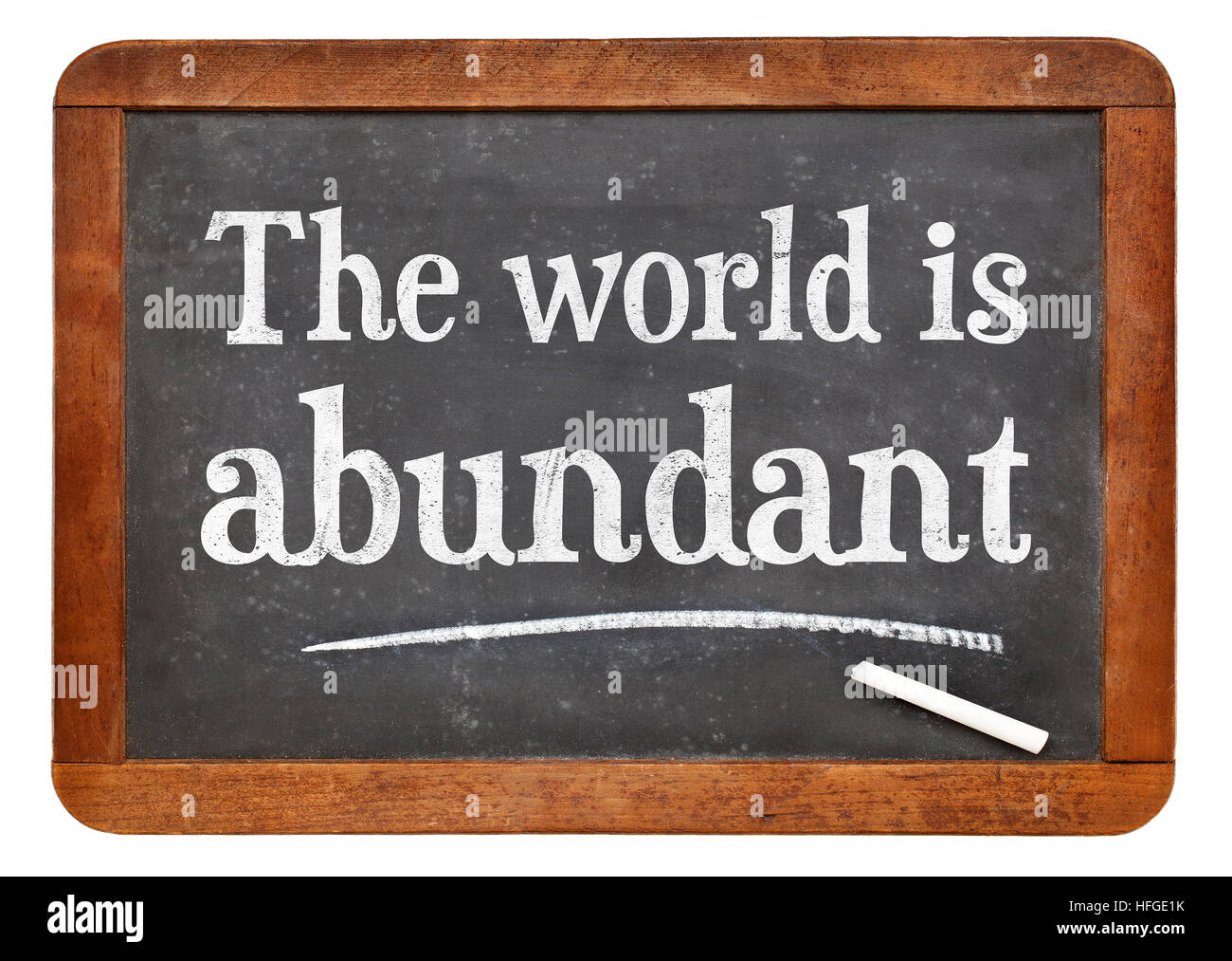 The world is abundant - white chalk text on a vintage slate blackboard ...