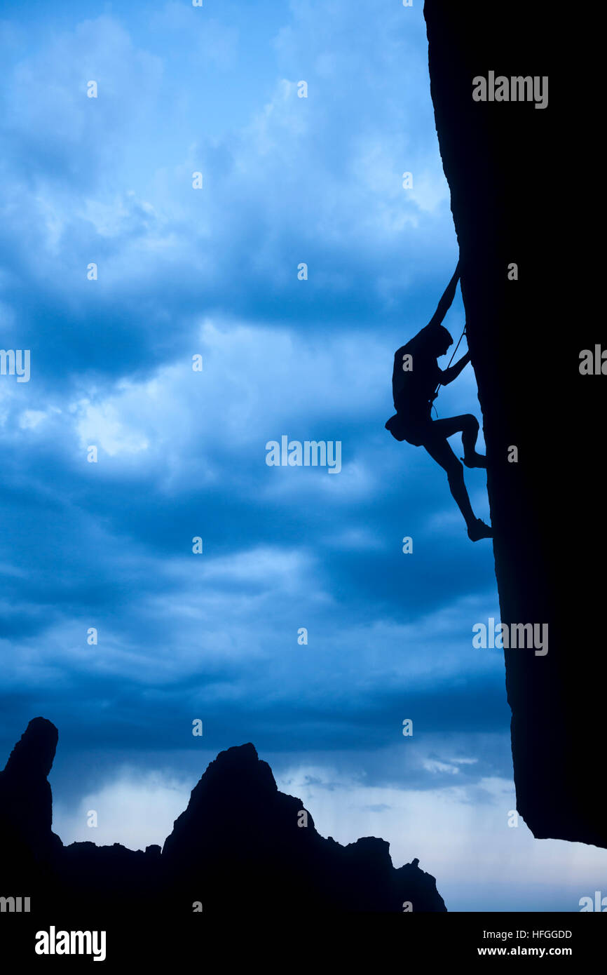 Male climber dangles from a sheer rock spire Stock Photo - Alamy