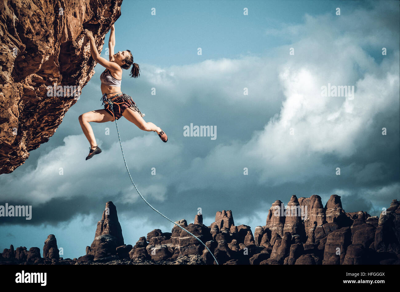 Female climber dangeling from the edge of a sheer rock mountain Stock ...