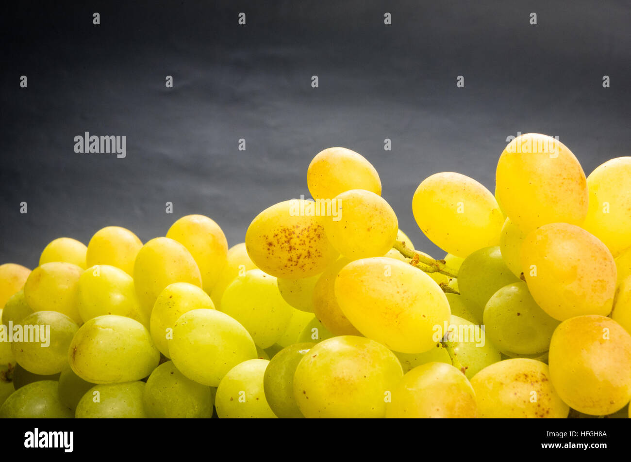 Large grapes cluster amber color on black background Stock Photo - Alamy