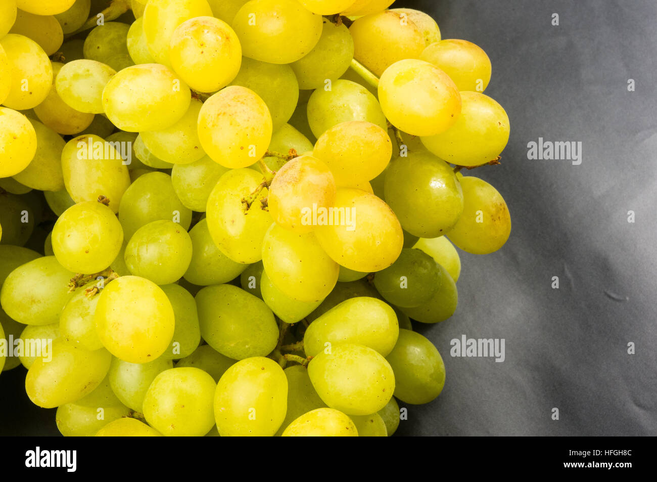 Large grapes cluster amber color on black background Stock Photo - Alamy