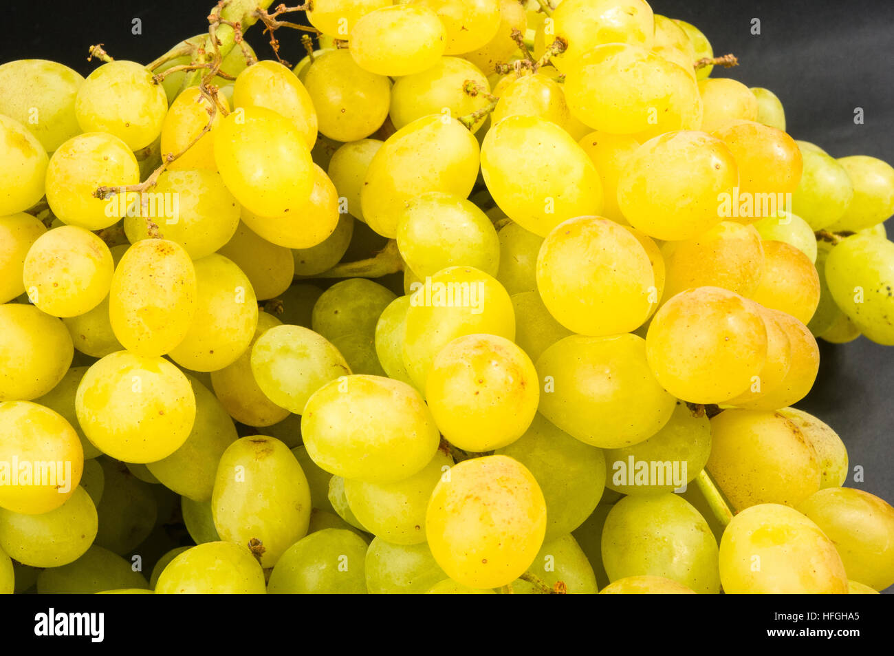 Large grapes cluster amber color on black background Stock Photo - Alamy