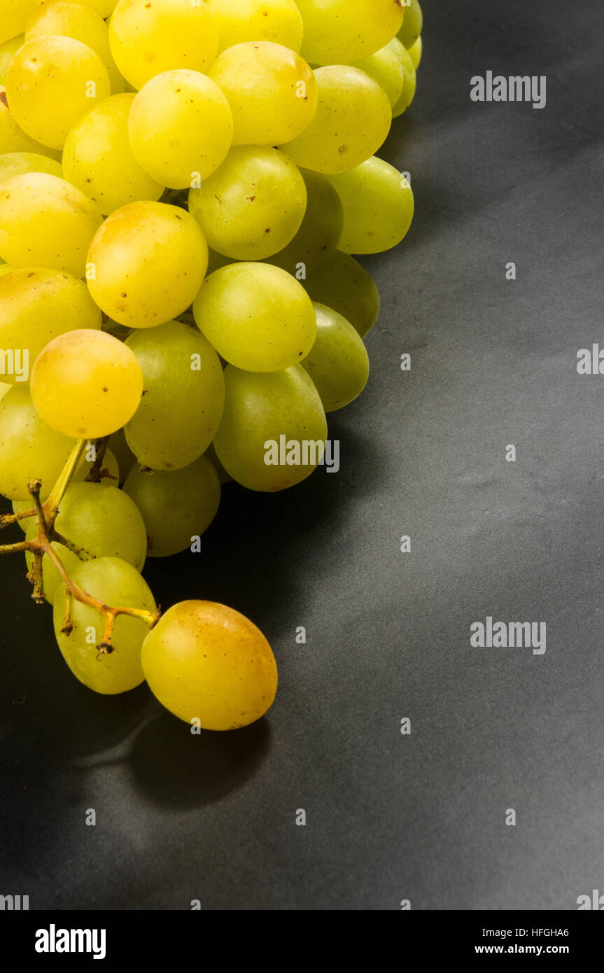 Large grapes cluster amber color on black background Stock Photo - Alamy