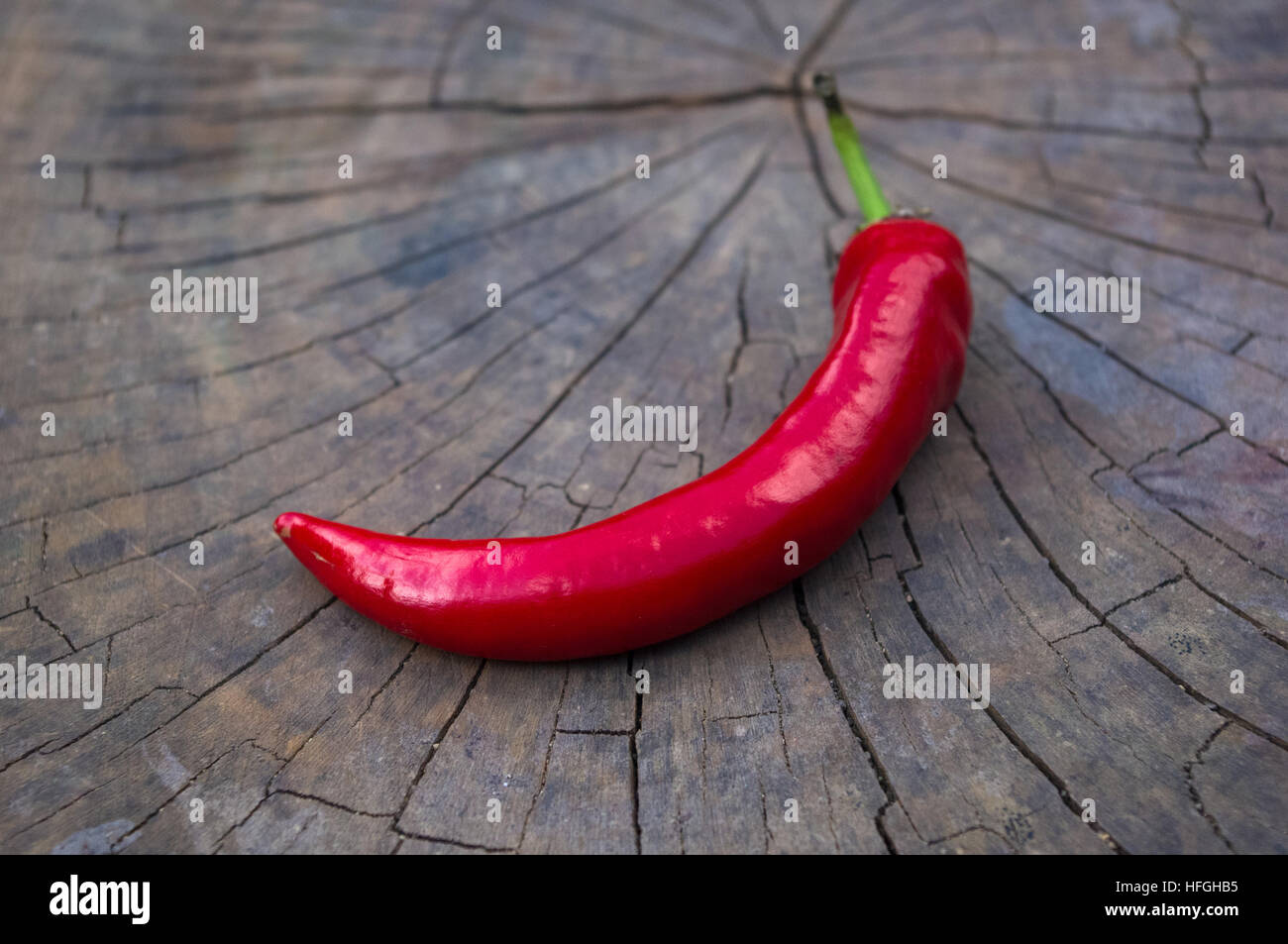 A pod of red hot chili peppers on the old worn wooden background Stock ...