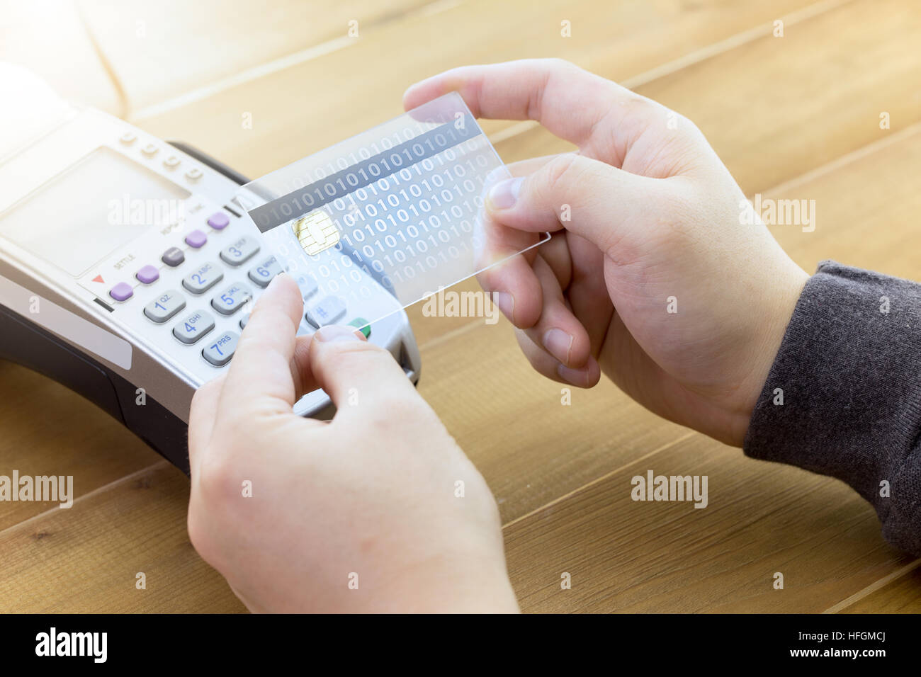 Cashier hand holding a debit or credit card over EDC machine or credit ...