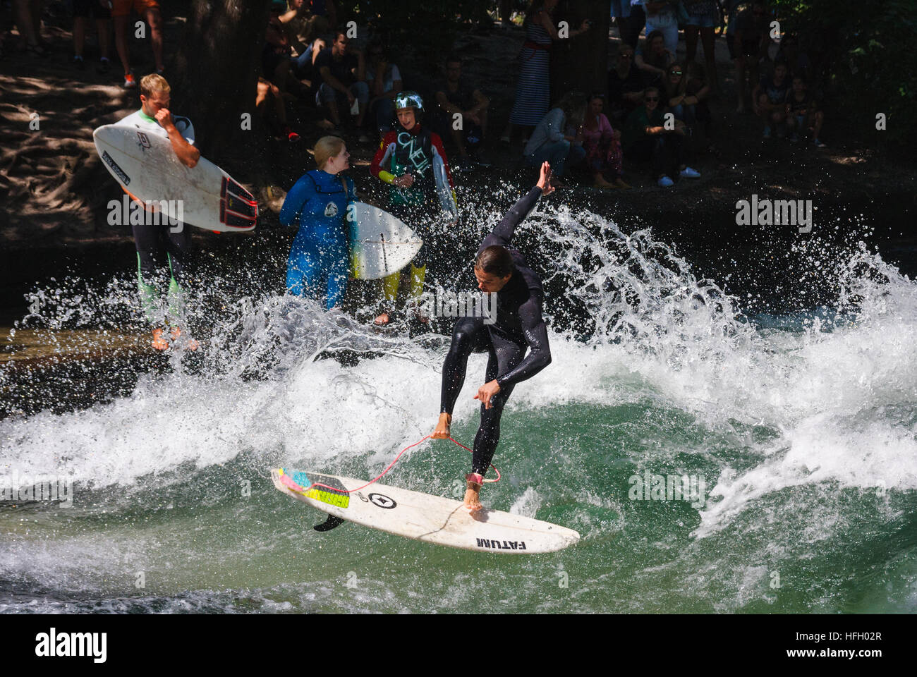 Surfer makes a jump on the artificial standing wave in the Eisbach in ...