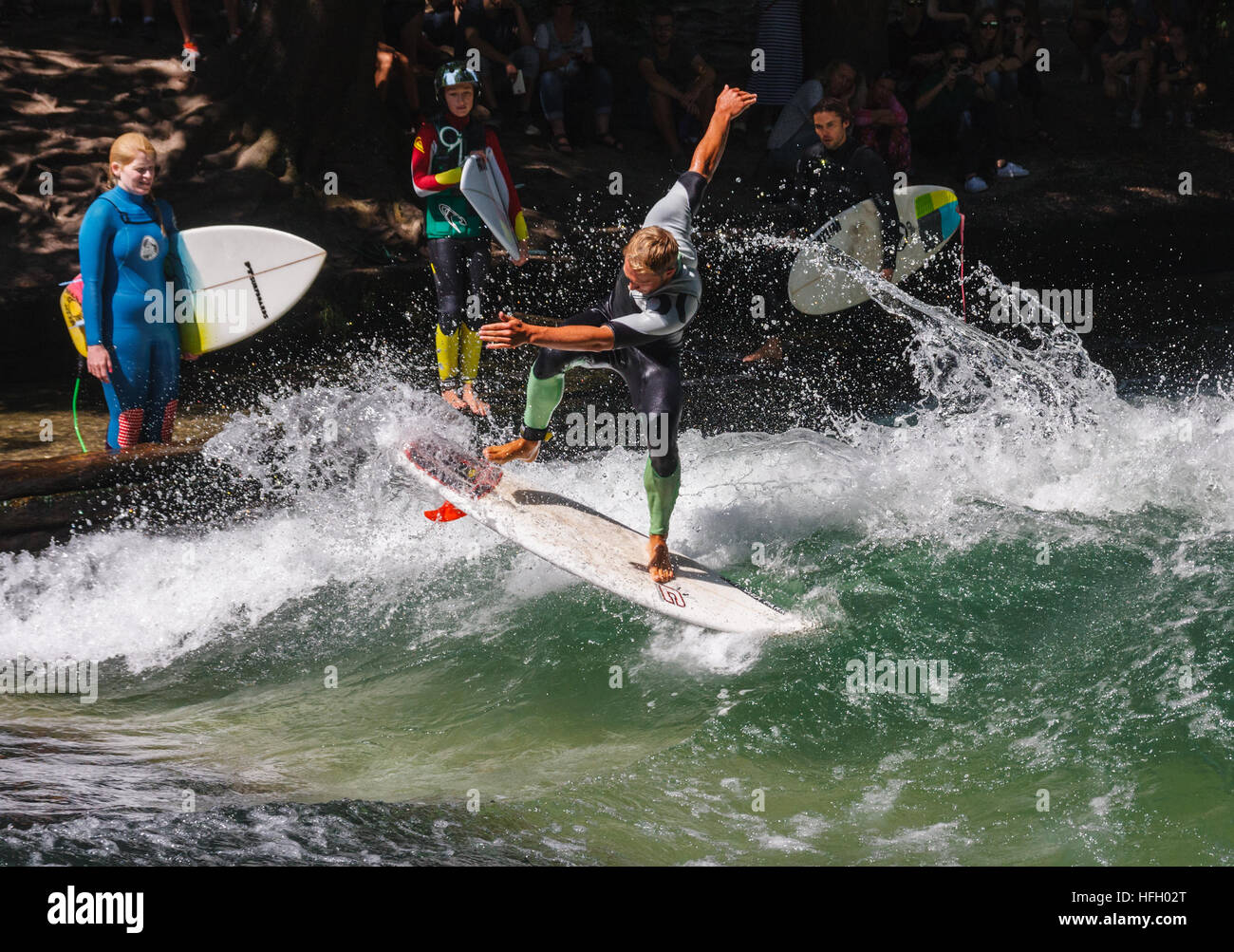 Surfer makes a jump on the artificial standing wave in the Eisbach in ...