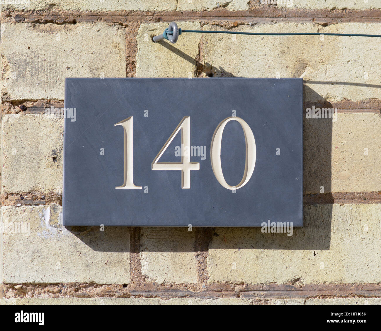 House Number 140 sign on wall Stock Photo - Alamy