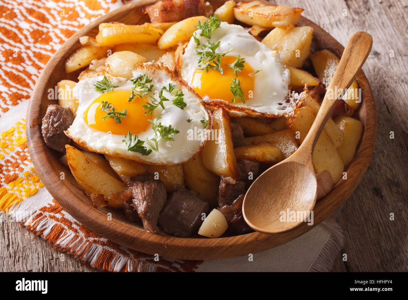Tyrolean cuisine: fried potatoes with meat, bacon and eggs close-up in ...