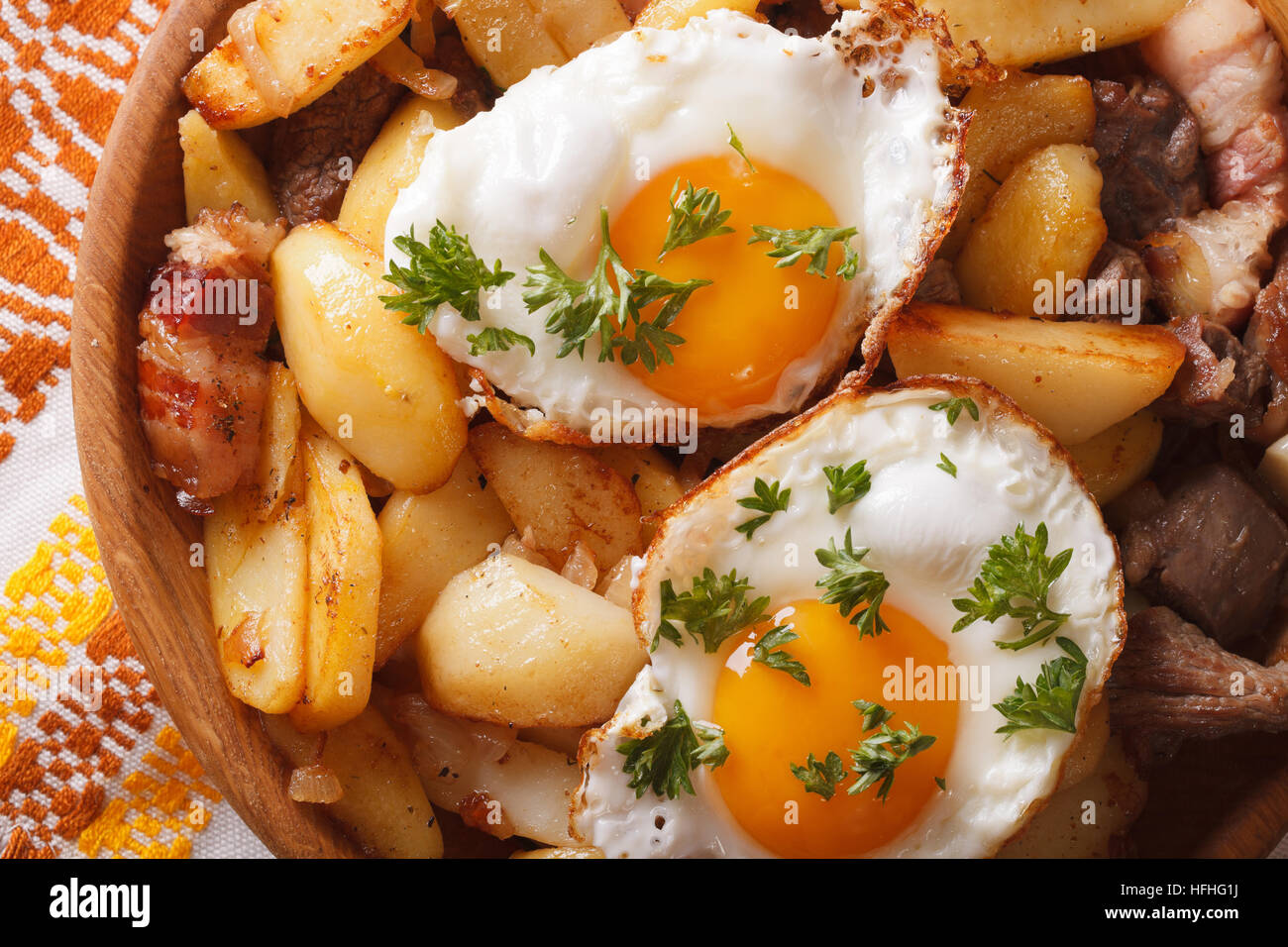 Austrian cuisine: fried potatoes with meat, bacon and eggs close-up in ...