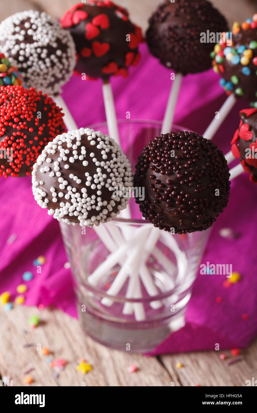 Beautiful chocolate cake pops with colorful candy sprinkles close up in ...