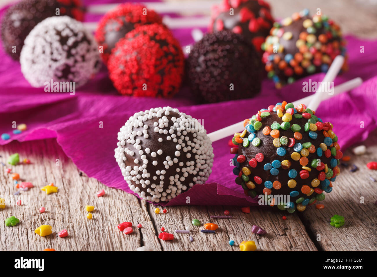 Festive chocolate cake pops with candy sprinkles close-up on the table ...