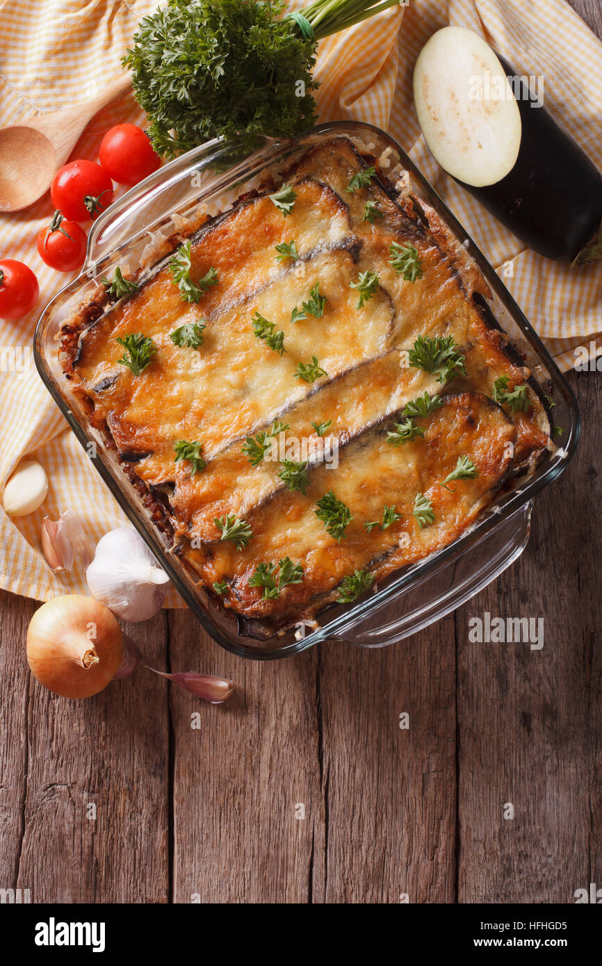 Greek moussaka in baking dish with the ingredients on the table ...