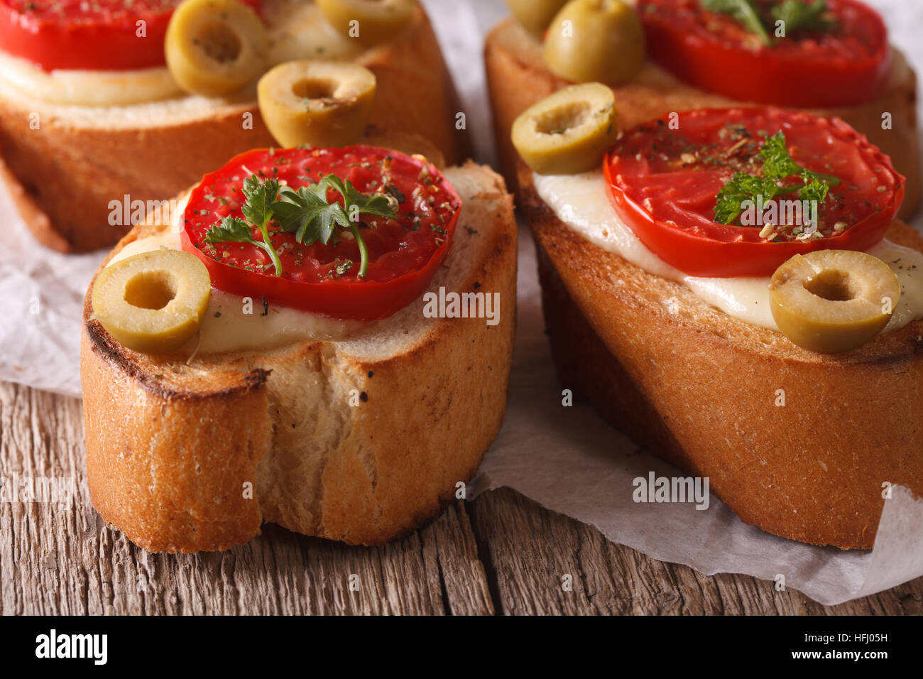 Italian crostini with baked tomatoes, olives and mozzarella cheese ...
