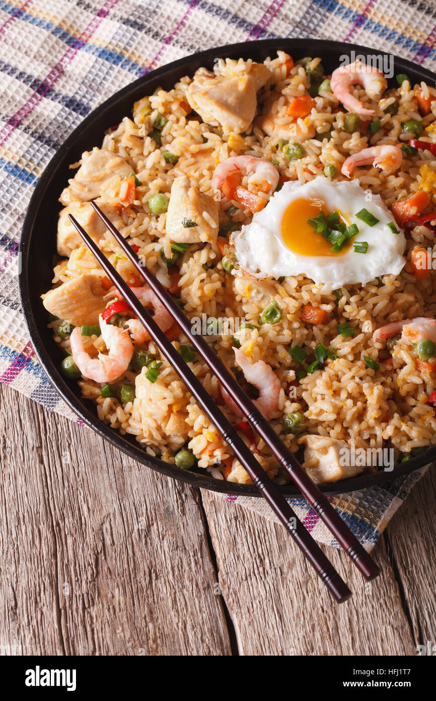 Asian fried rice with chicken, prawns, egg and vegetables close-up ...