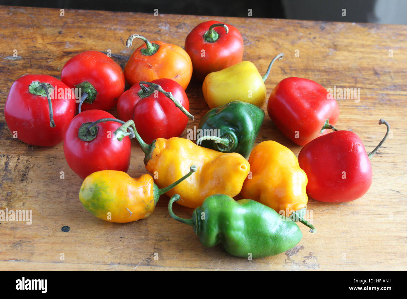 Group of whole, colorful hot peppers on a wooden table Stock Photo - Alamy