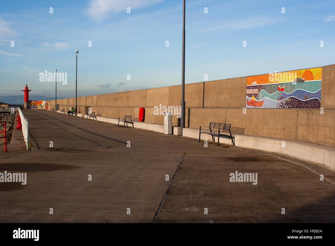 A modern harbor pier built of concrete with a colorful mosaic mural on ...