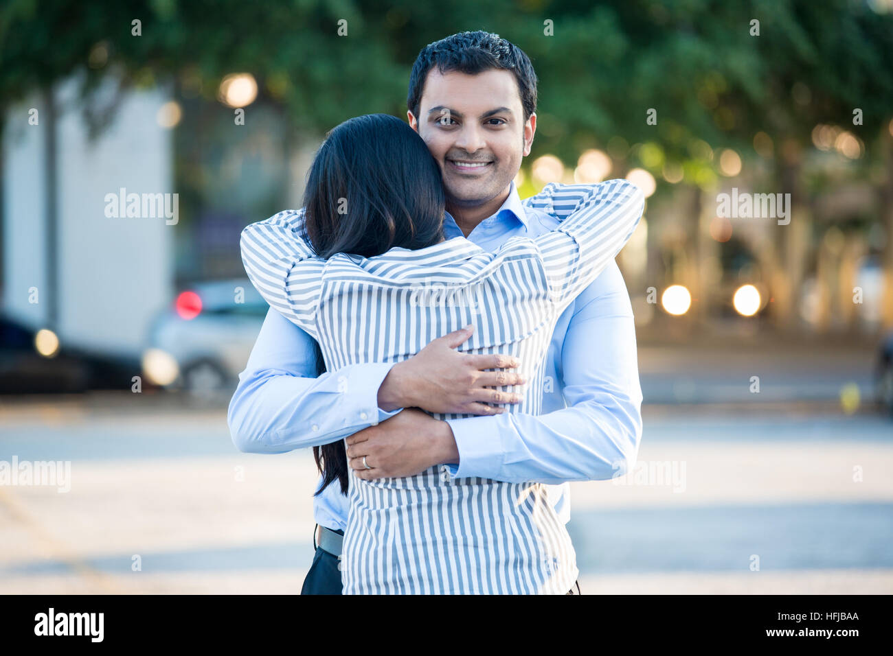 Closeup portrait back view, young couple in blue shirt, hugging ...