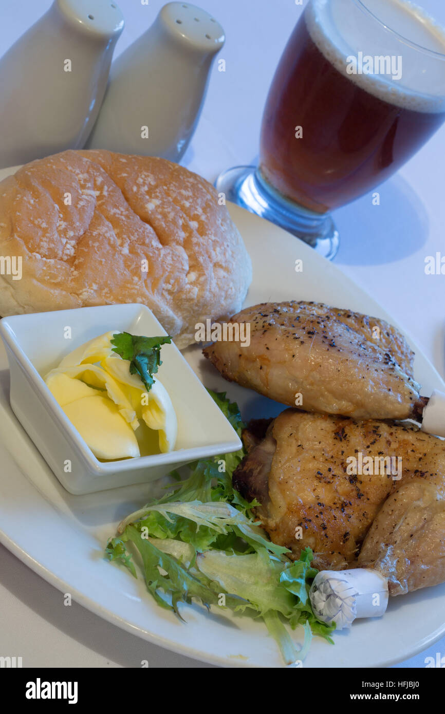 Oven roasted Chicken Legs served with salad and a fresh bread bun Stock ...