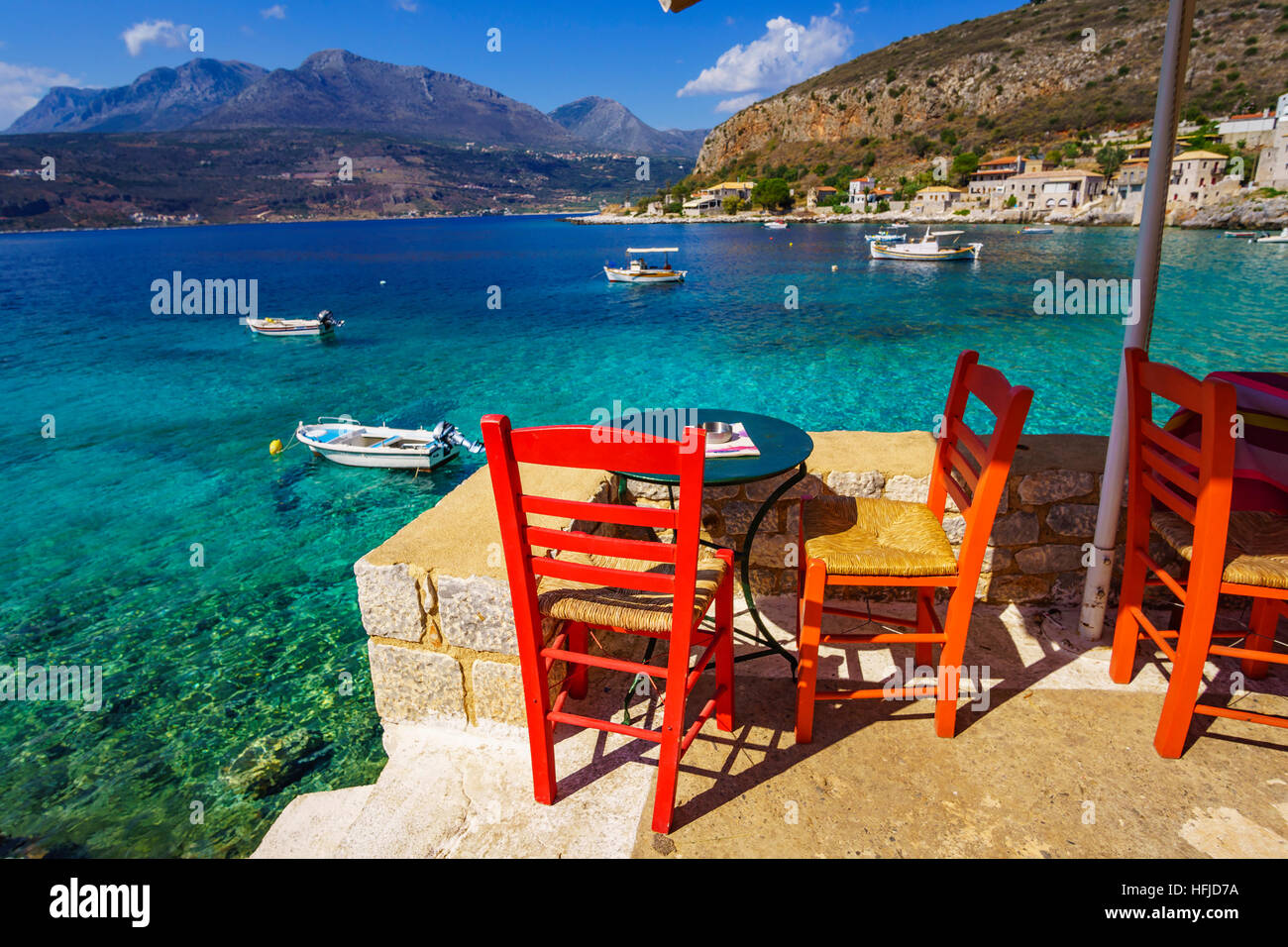 Traditional chairs with a table near the beautiful Greek sea at Limeni ...