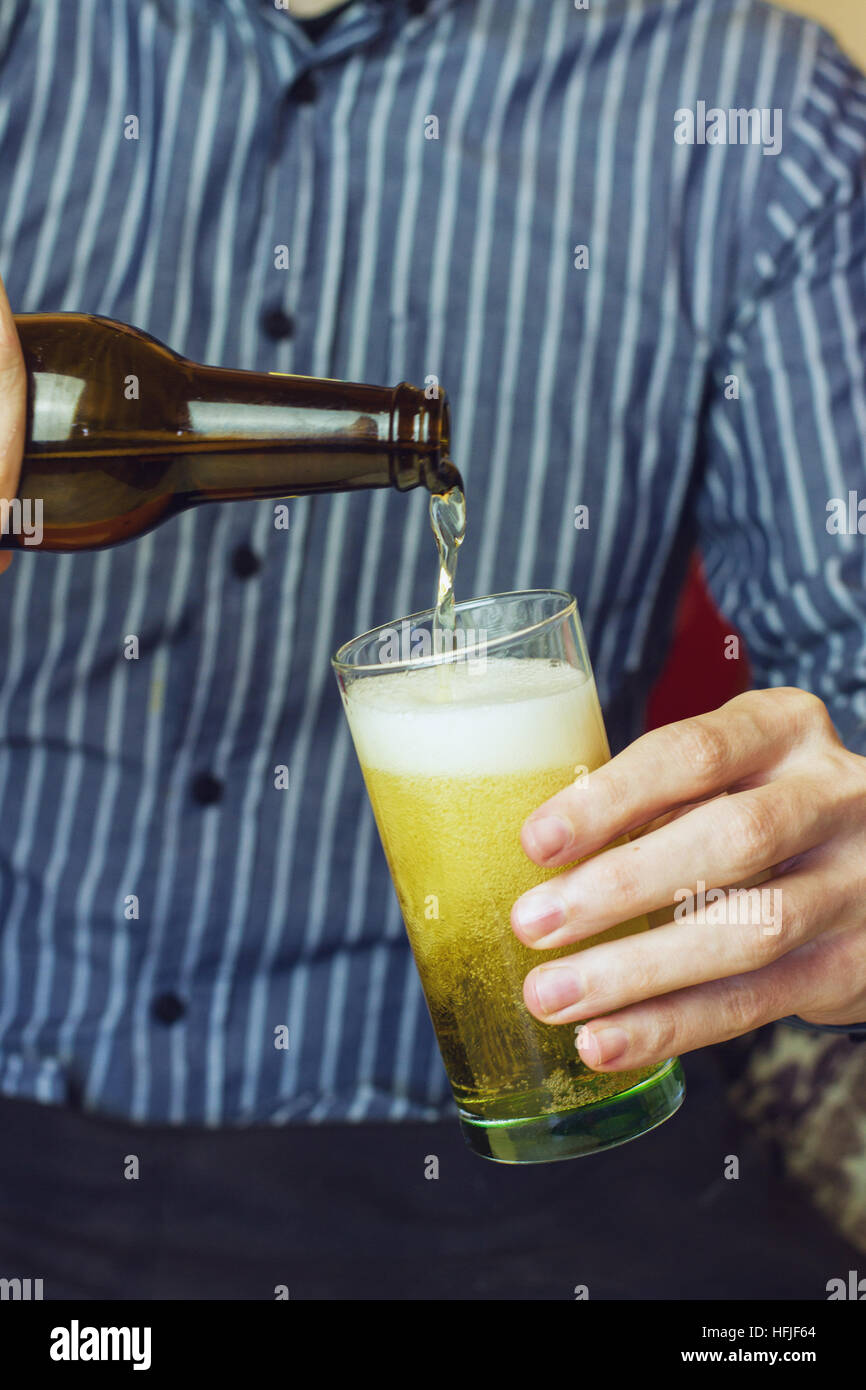 Young man serving a blonde beer Stock Photo - Alamy